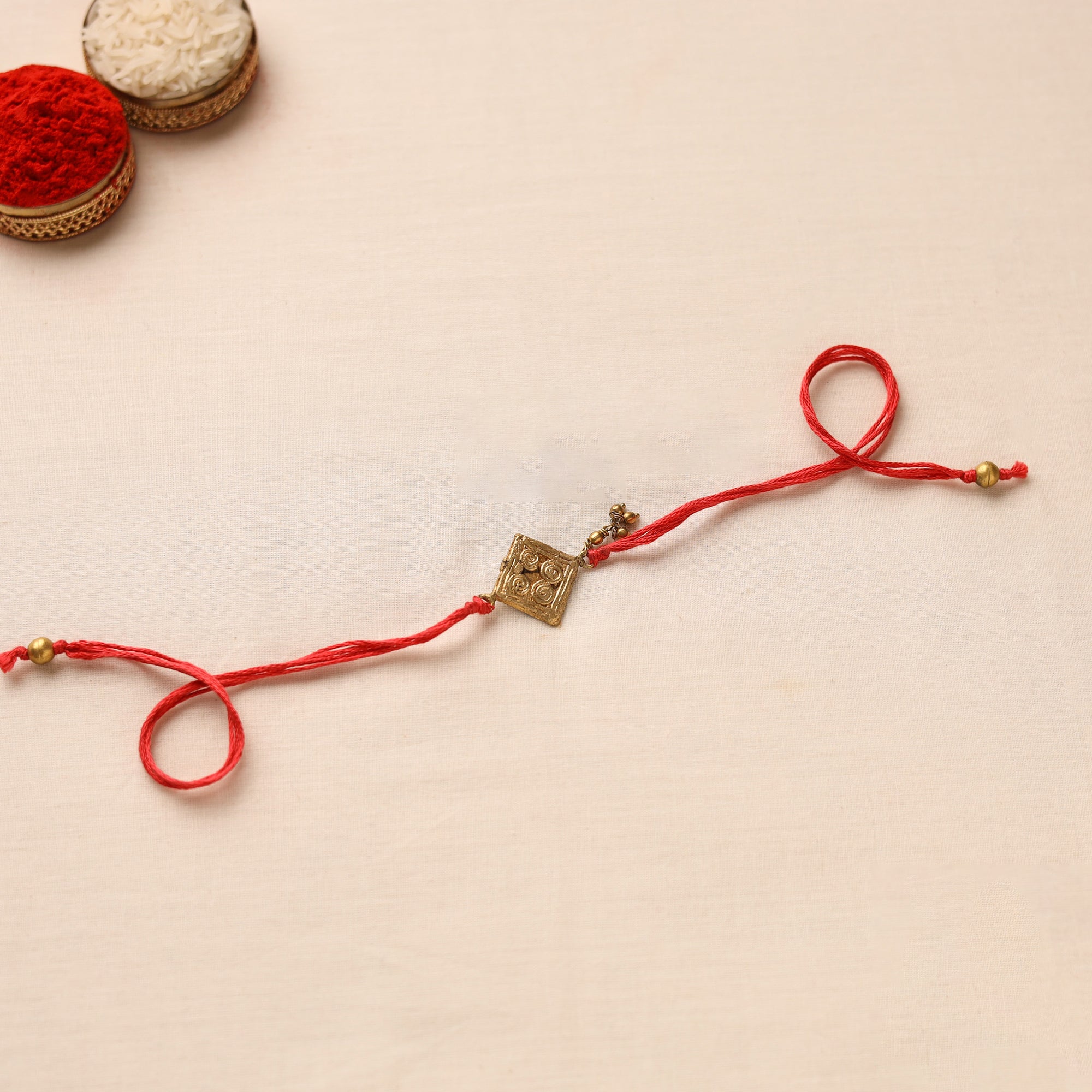 Tribal Dokra Craft Brass Rakhi by Miharu